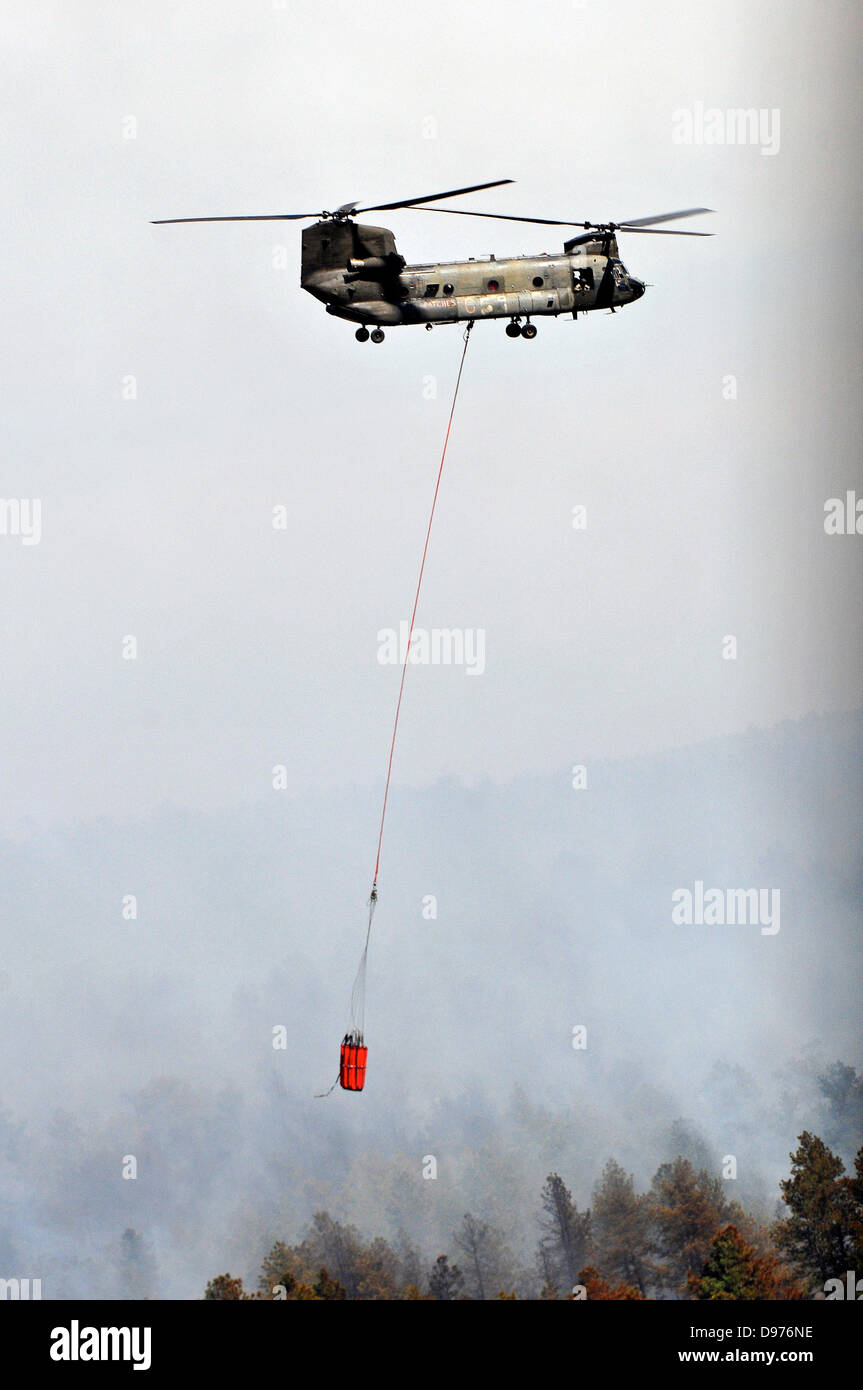 A US National Guard CH-47 Chinook helicopter carries water to assist in ...