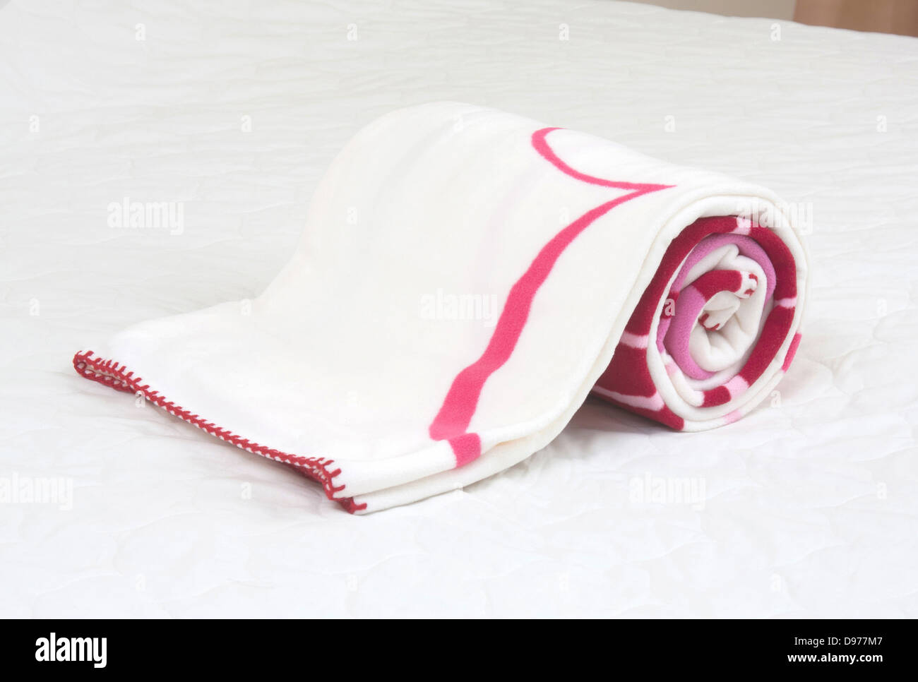 Small fleece blanket on white bed Stock Photo - Alamy