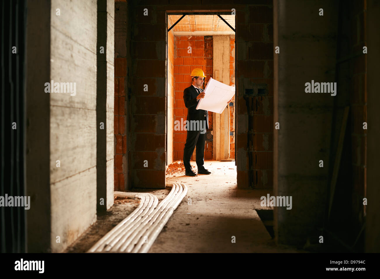 Engineer at work in construction site, standing in apartment building ...