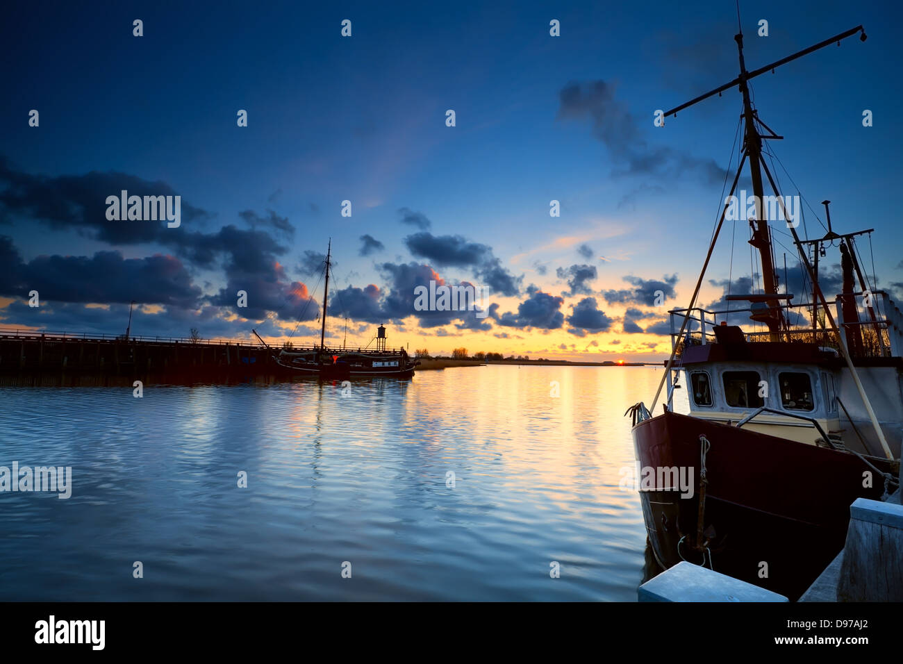 Dutch fishing boats on river at sunset, Zoutkamp, Netherlands Stock ...