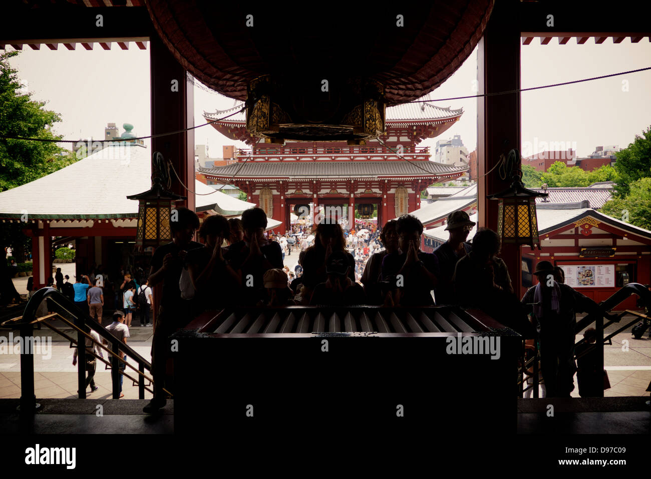 Visitors offering their prayers at the Main Hall of Senso-ji Temple ...