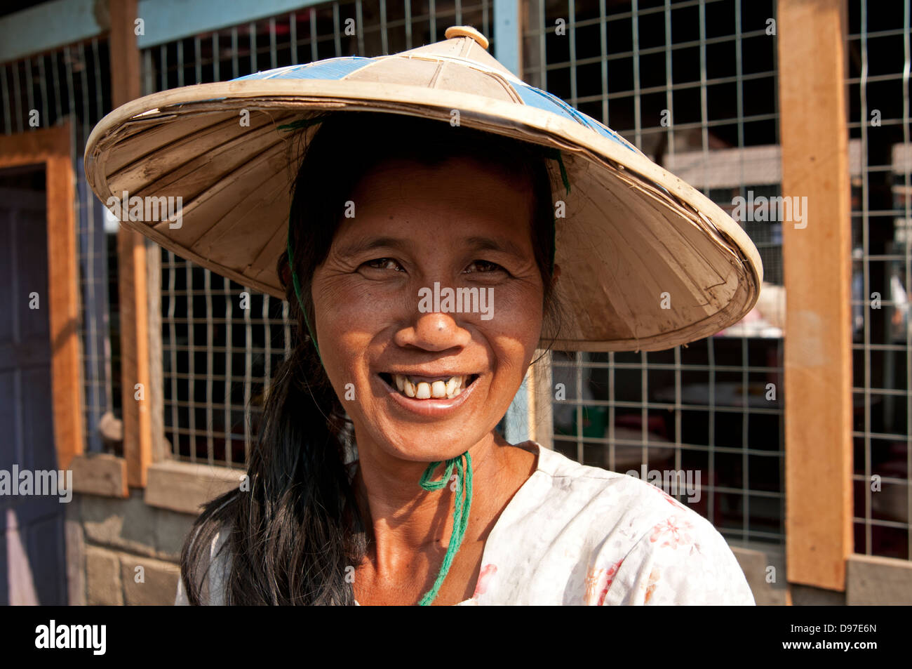 Burmese woman wearing a bamboo conical Shan states hat smiling at the ...