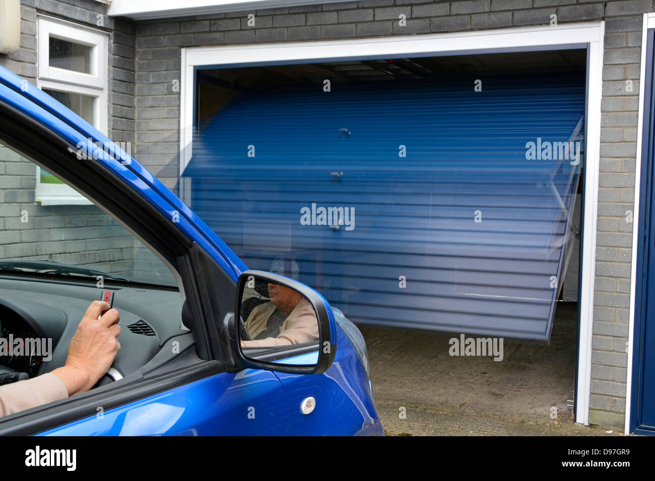 GWoman car driver operating Henderson remote control to open or close ...