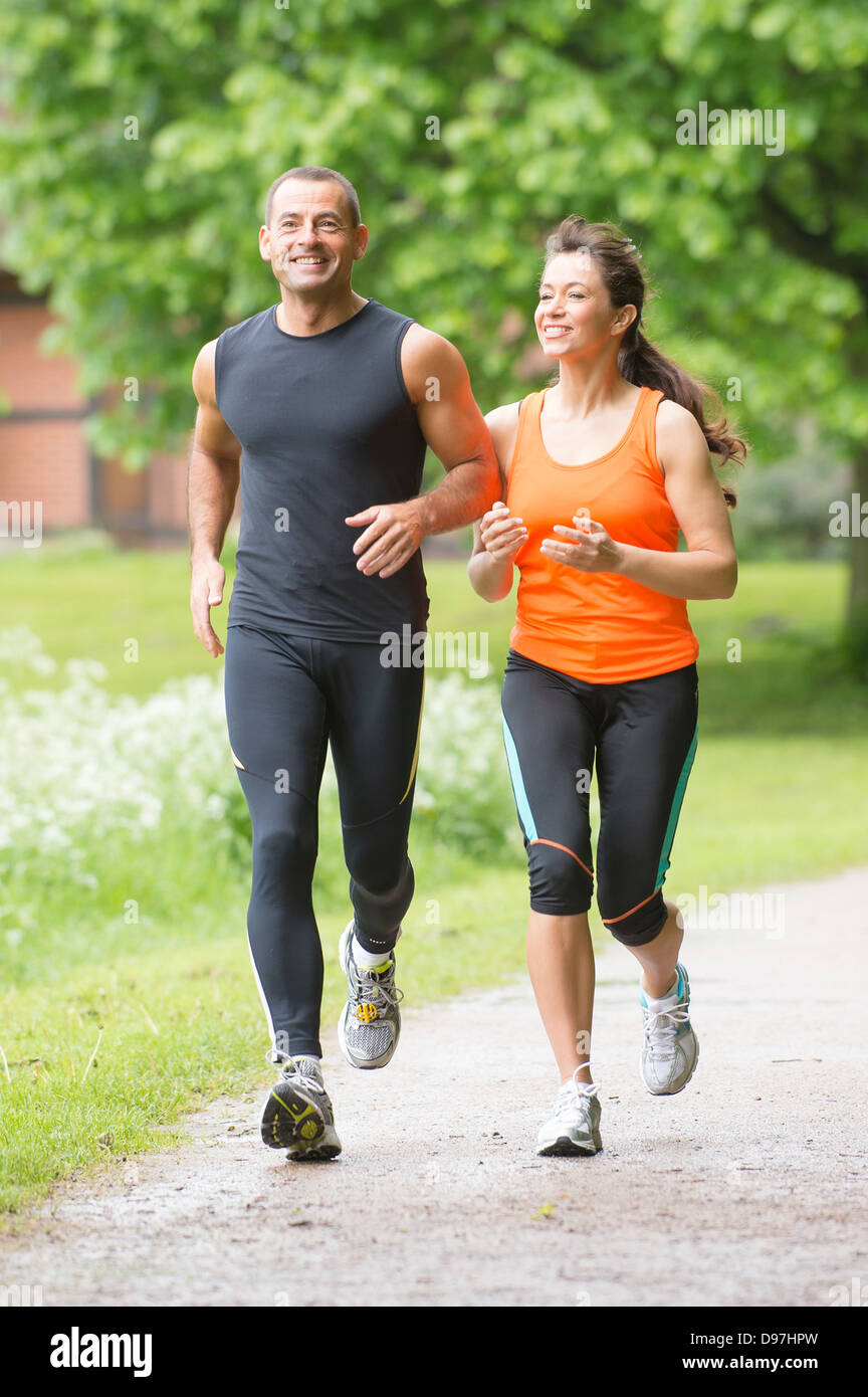 Sport couple running in park Stock Photo - Alamy
