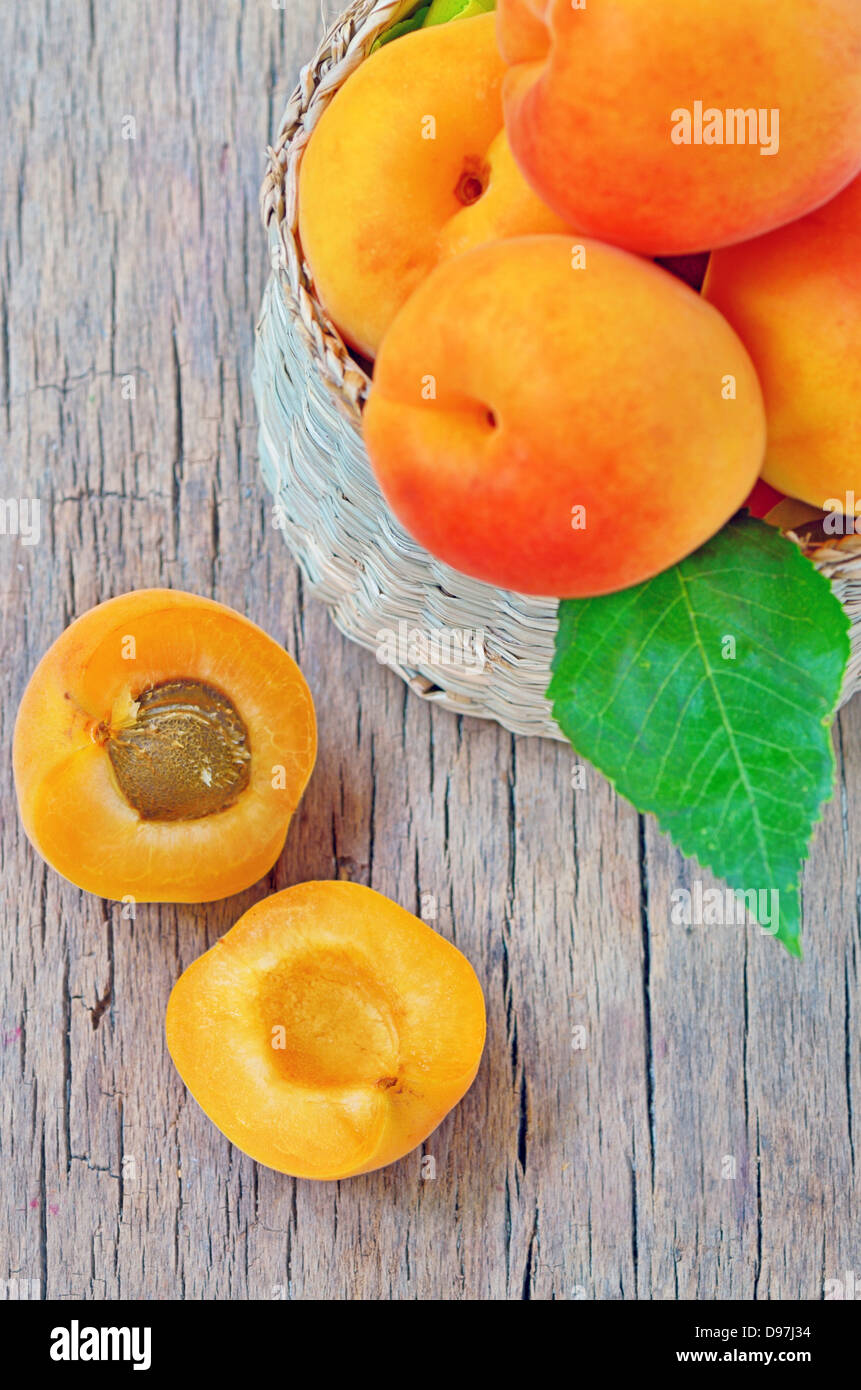 apricot fruits with green leaf and cut isolated on wooden background ...