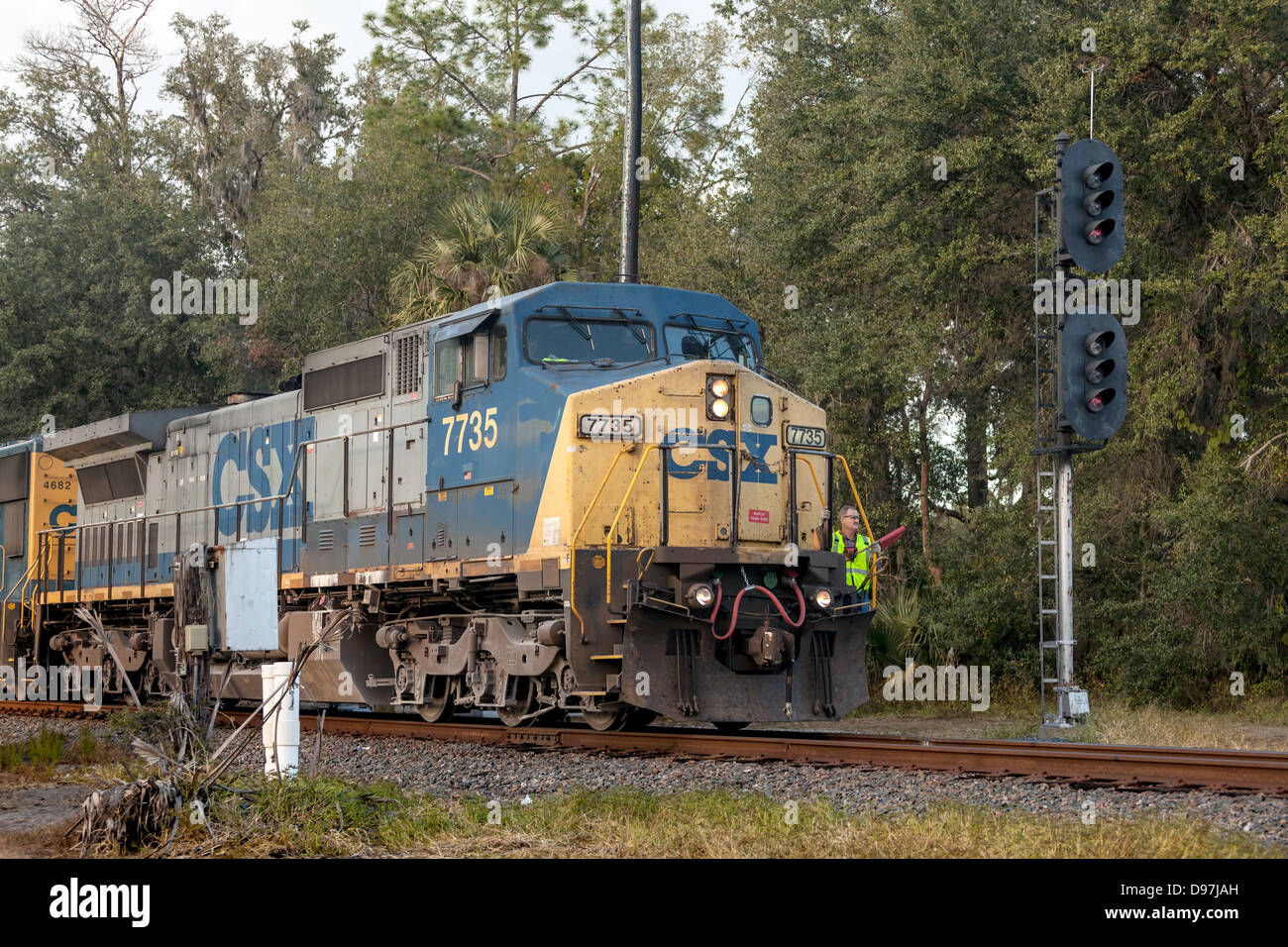 CSX engine 7735 with a flagman is pulling a freight train through a ...