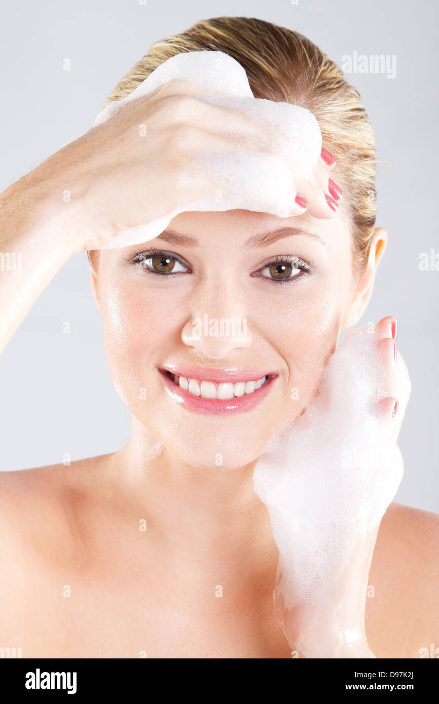 Beautiful young Caucasian woman washing her face with foam Stock Photo ...