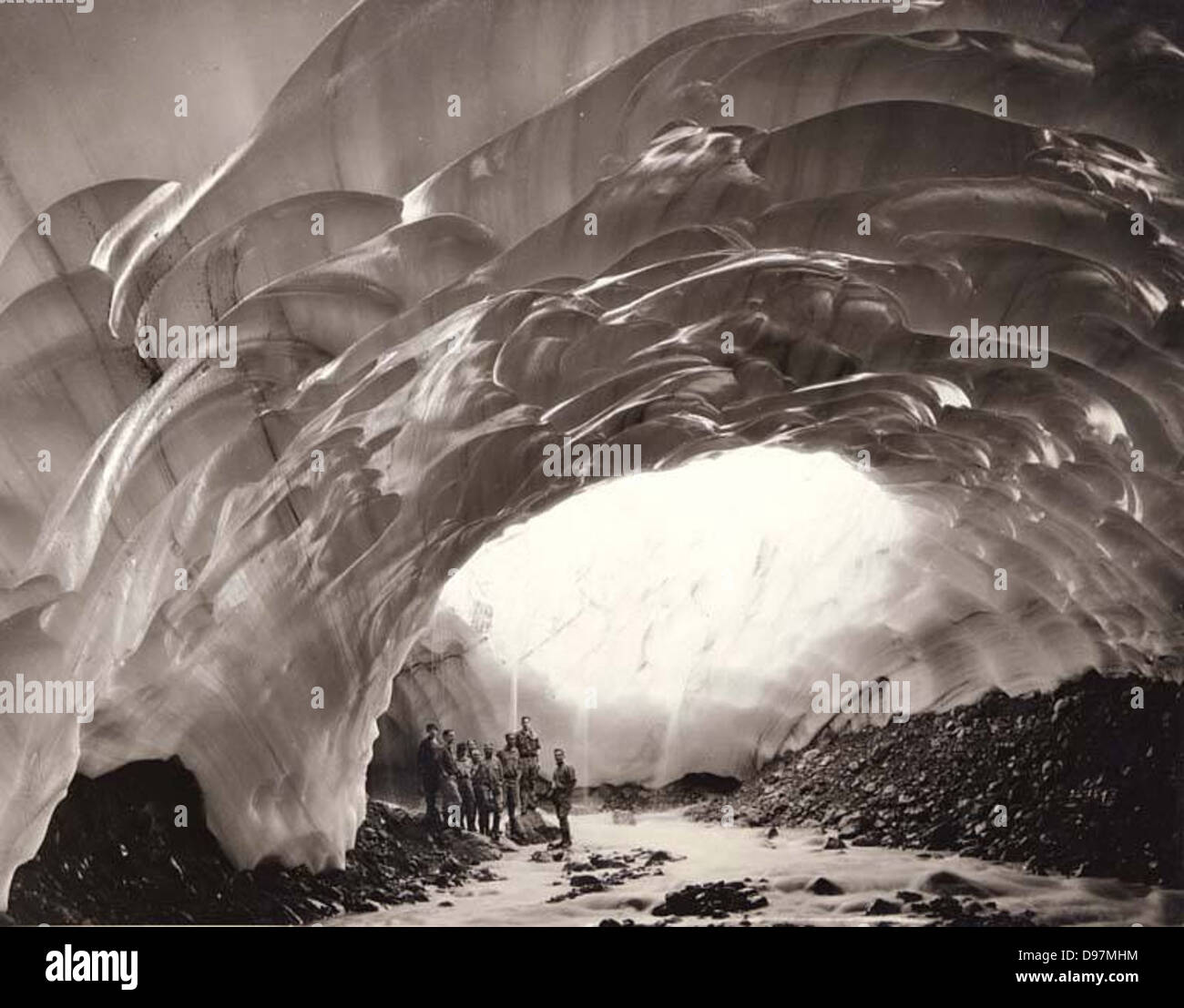 This photograph captures a group of boys exploring an ice cave in the ...