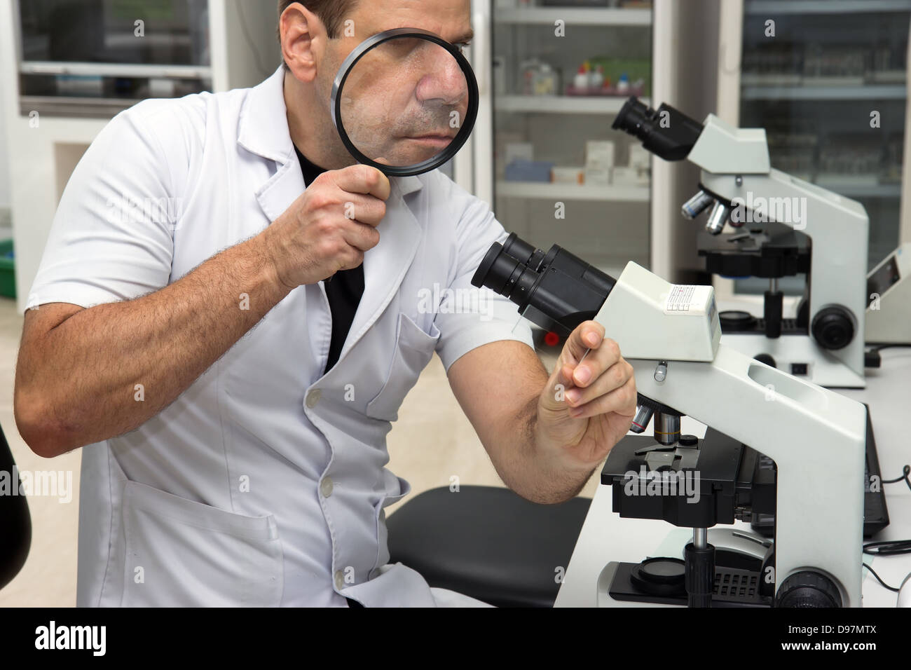 Man working with a microscope in Laboratory Stock Photo - Alamy
