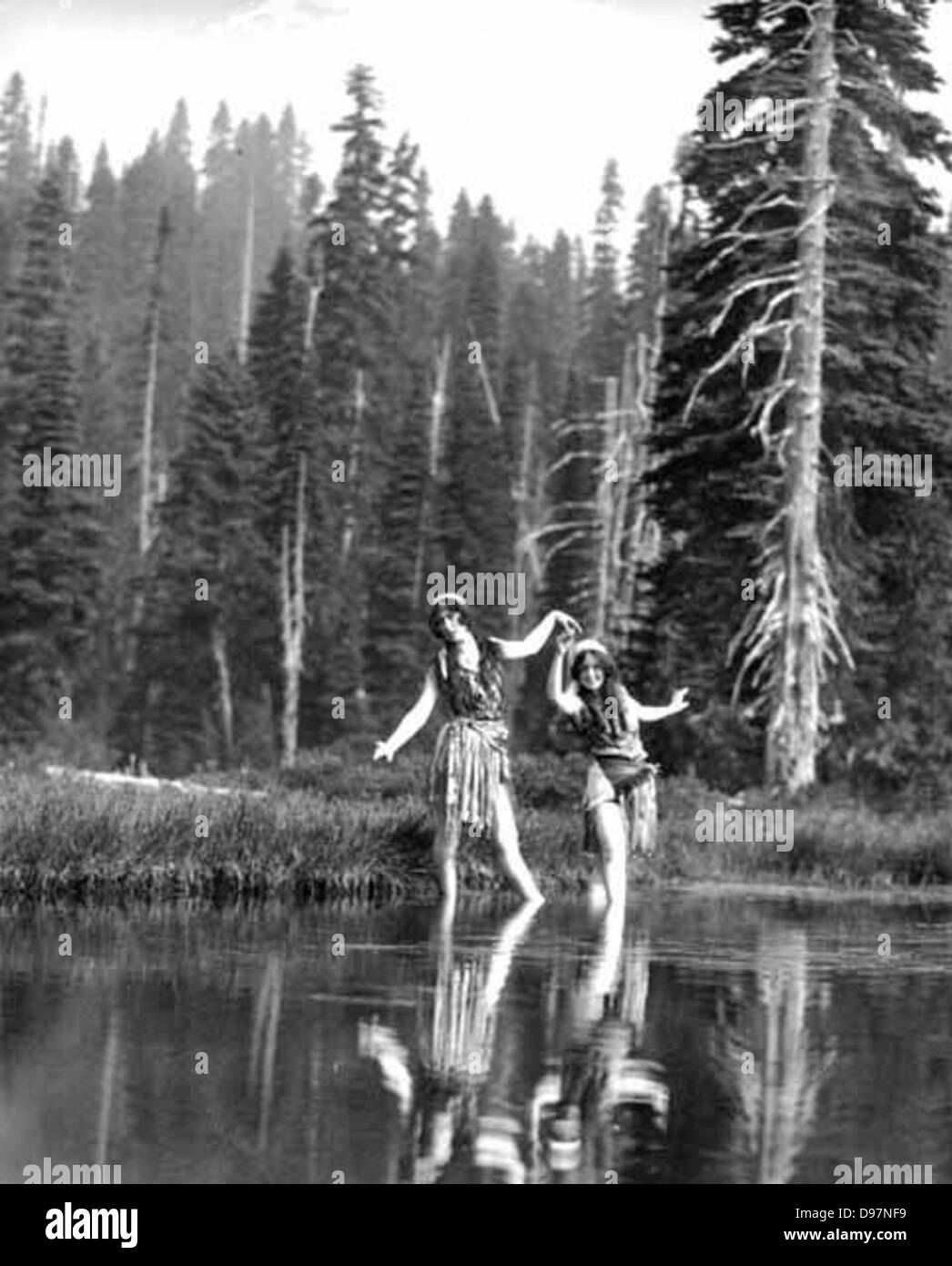 Two women dancers, dressed as gypsies, are seen wading in a lake. This ...
