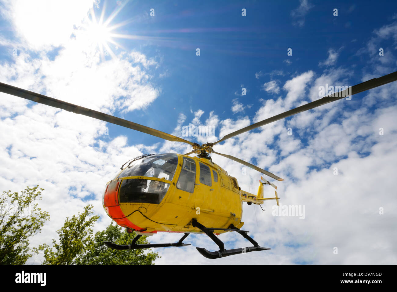 Yellow medical rescue helicopter flying above trees Stock Photo - Alamy
