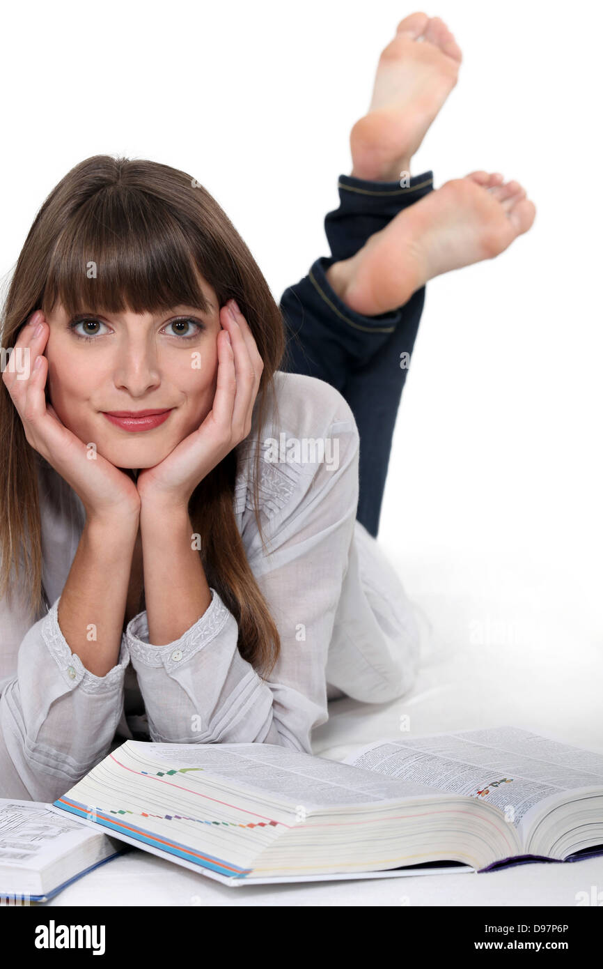 Relaxed girl reading encyclopedia Stock Photo - Alamy