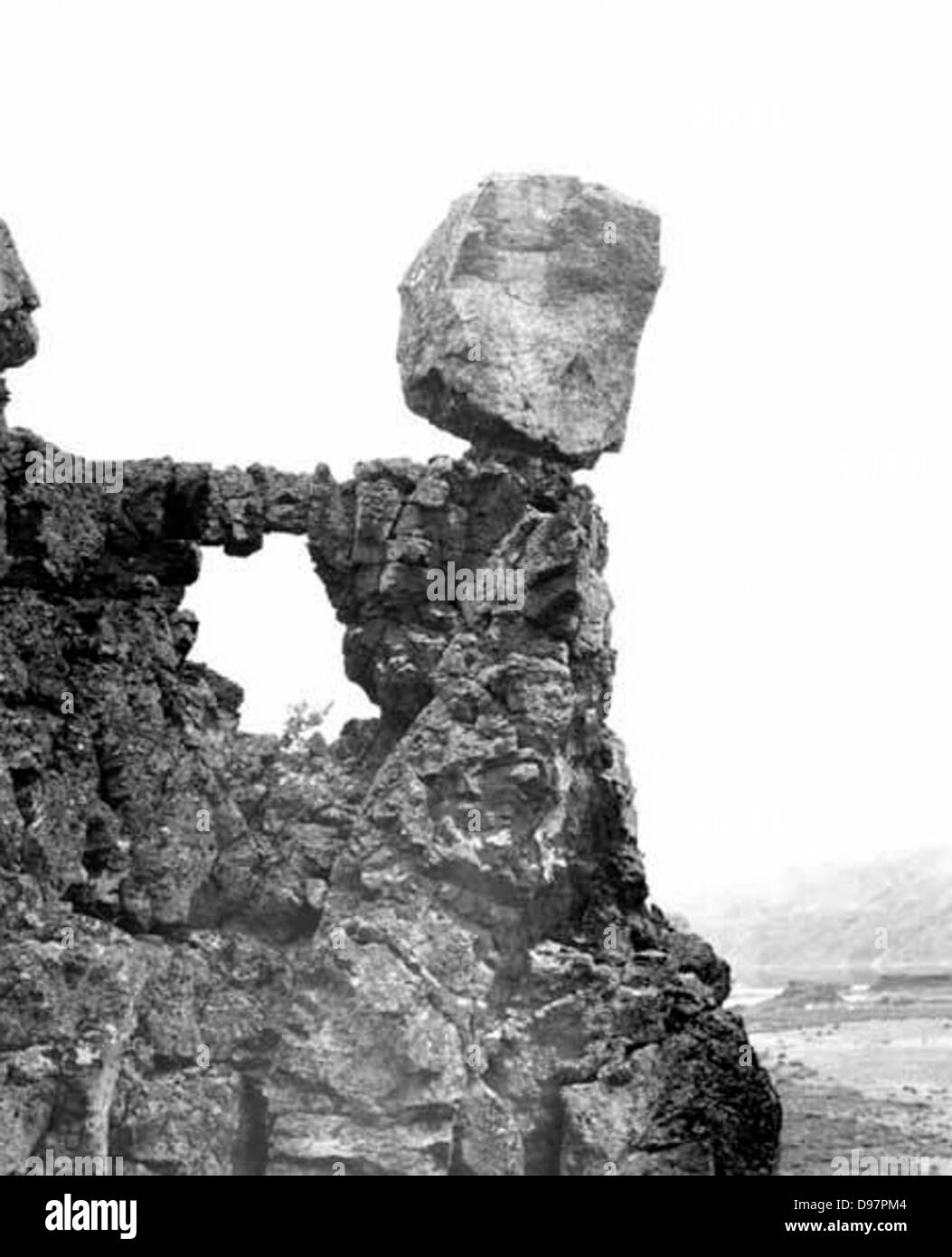 A precariously balanced rock sits above a volcanic lava arch near Park ...