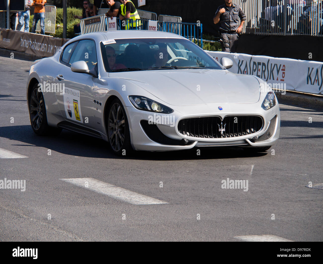 A Maserati is driven along Itzchak Kariv Road warming up spectators as ...