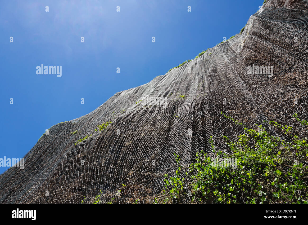Maui coastline with rock retaining wall to protect cars Stock Photo - Alamy