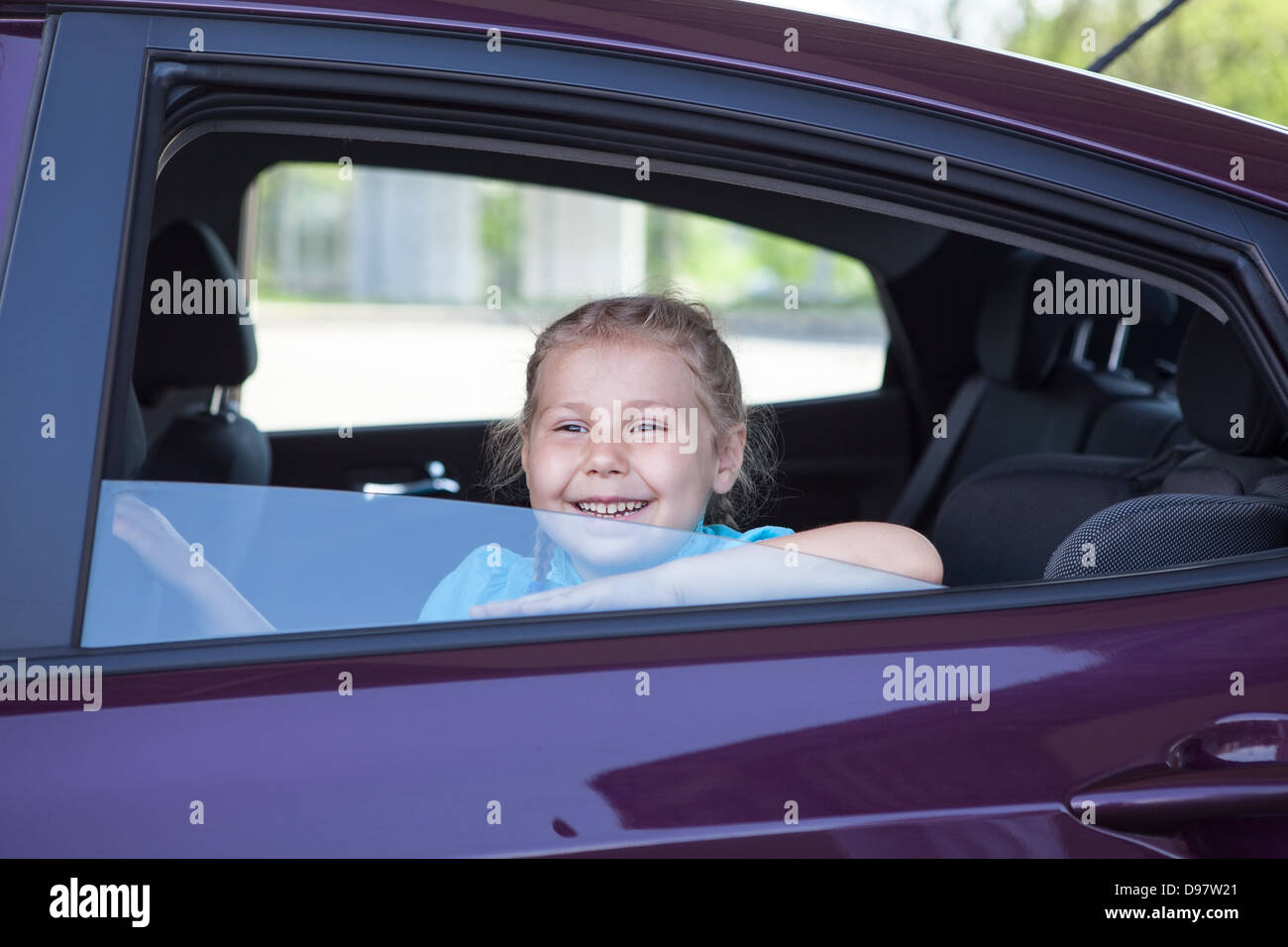 Little smiling Caucasian girl sitting inside of car on back seat Stock ...