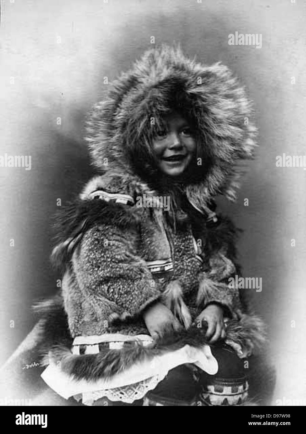 An Inuit child is seen wearing a traditional fur parka in this ...