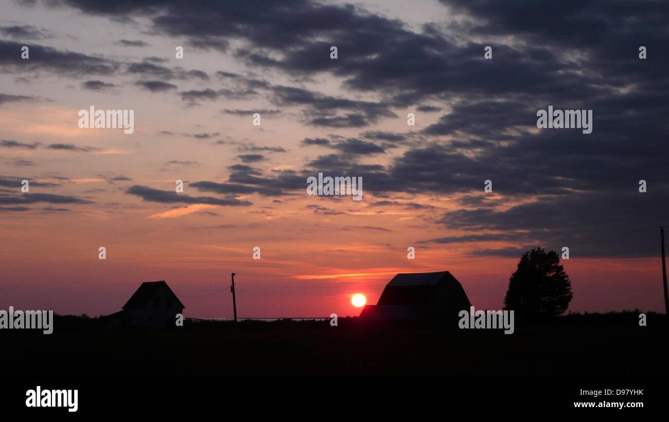A sunset behind a farm house and barn in Prince Edward Island Stock ...