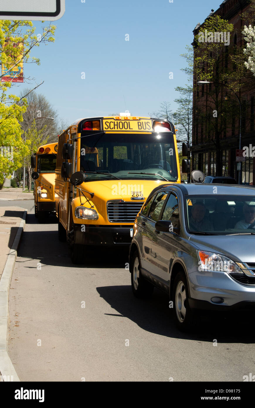 School buses on city street Stock Photo - Alamy