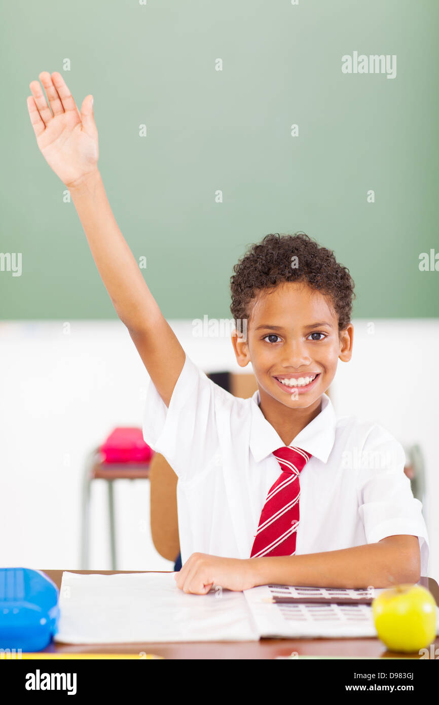 cute elementary schoolboy arm up in classroom Stock Photo - Alamy