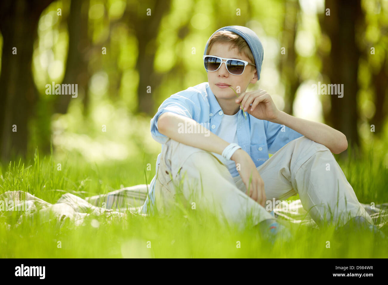 Portrait of cute lad in casual clothes and sunglasses having rest ...