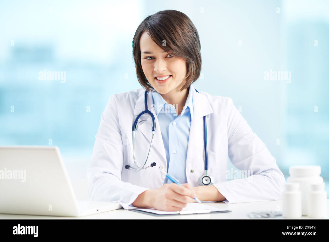Portrait of a smiling physician working in her office Stock Photo - Alamy