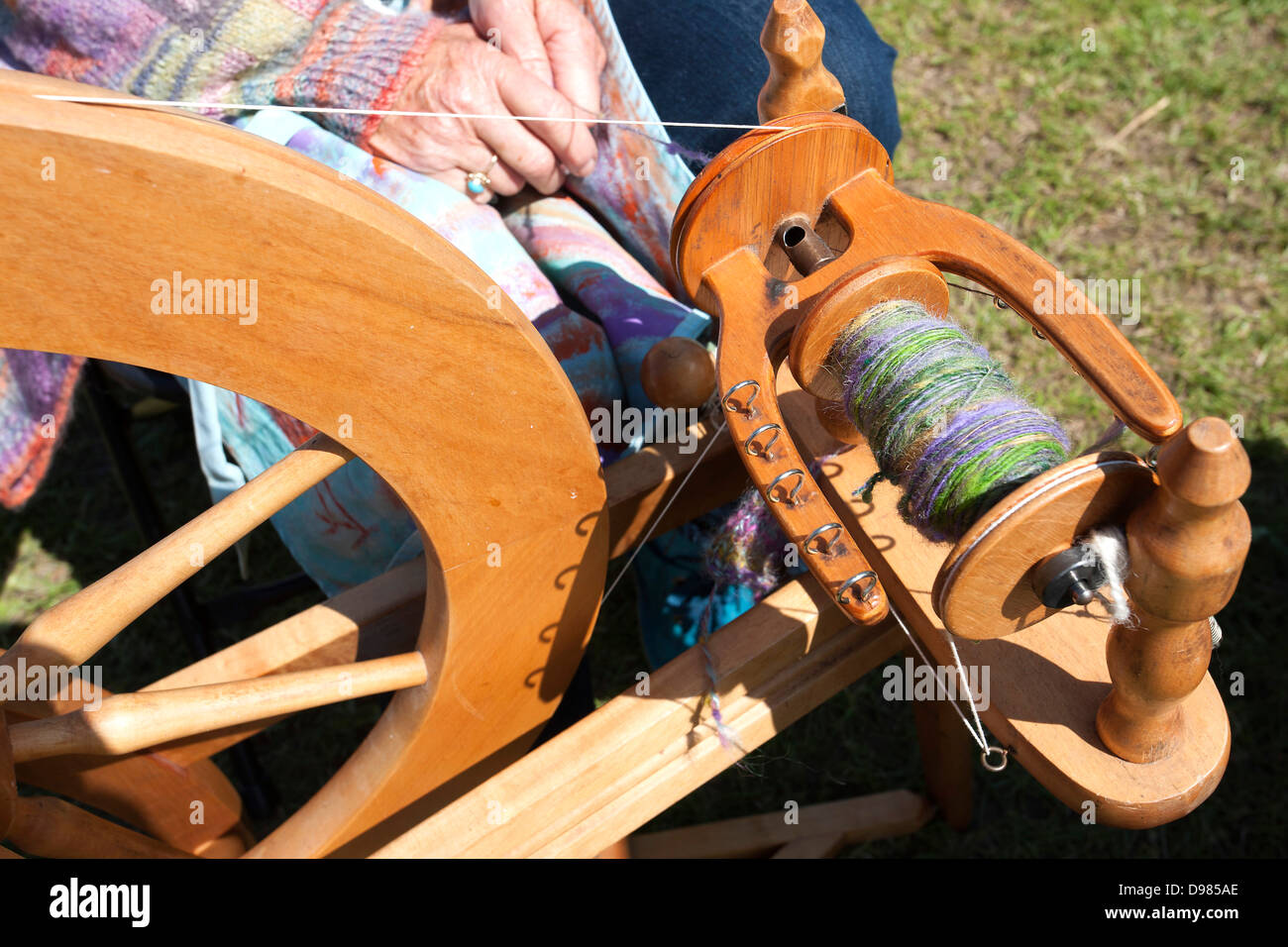 A lady spinning wool on a spinning wheel Stock Photo - Alamy