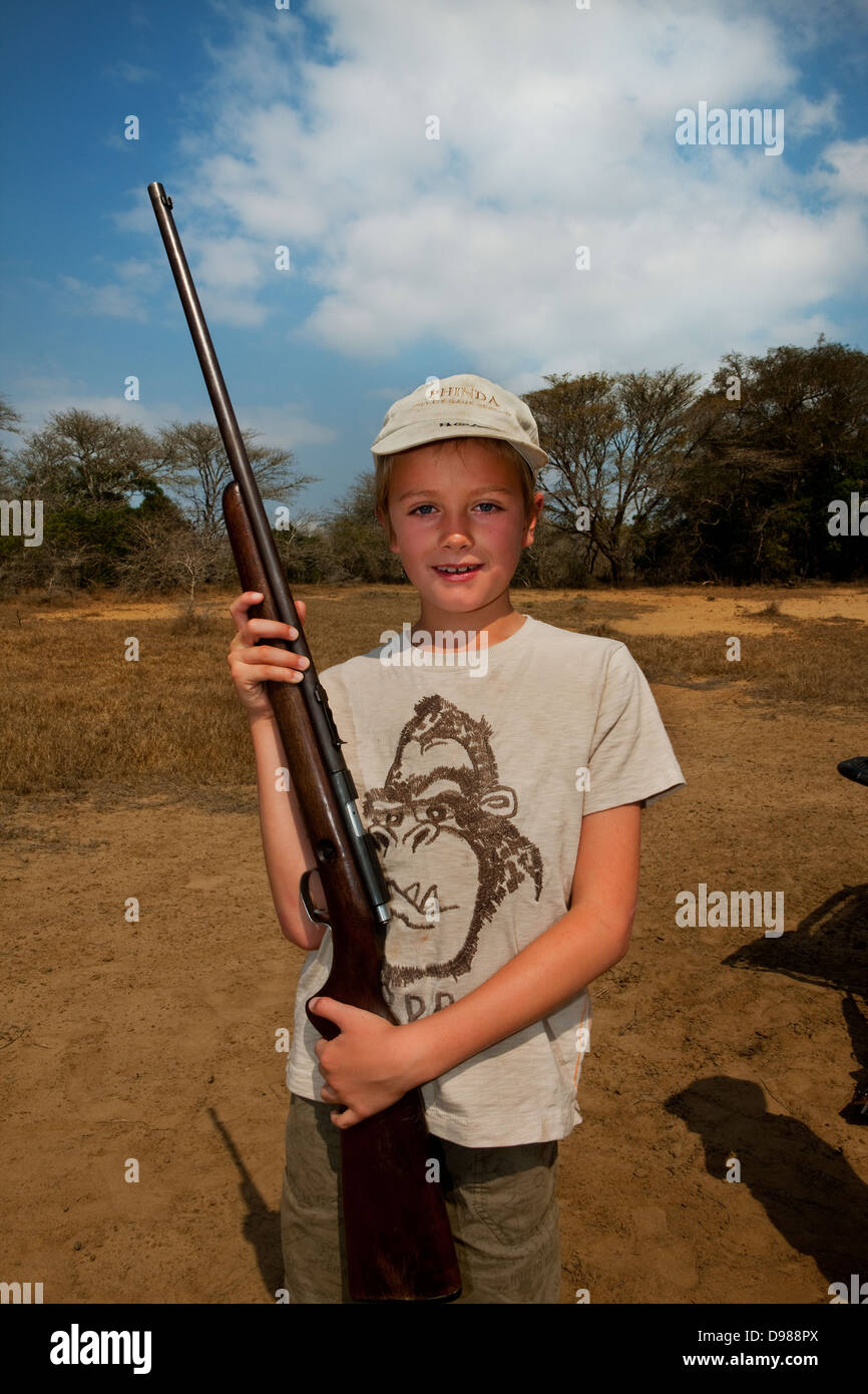 A boy learning to shoot with a rifle at the Phinda Game Reserve, South ...