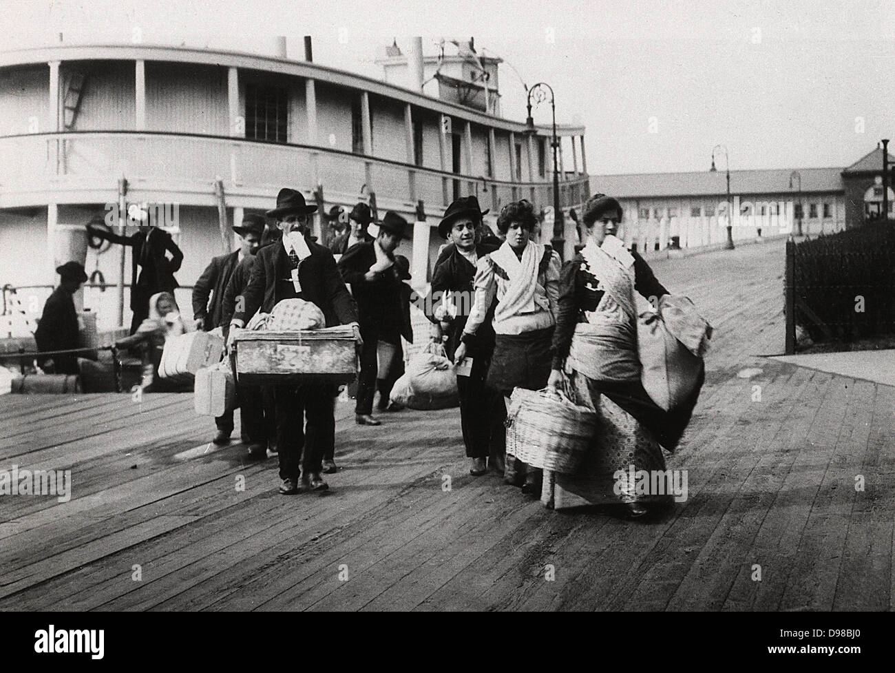 Imigrants to US landing at Ellis Island circa 1900. They head for the ...