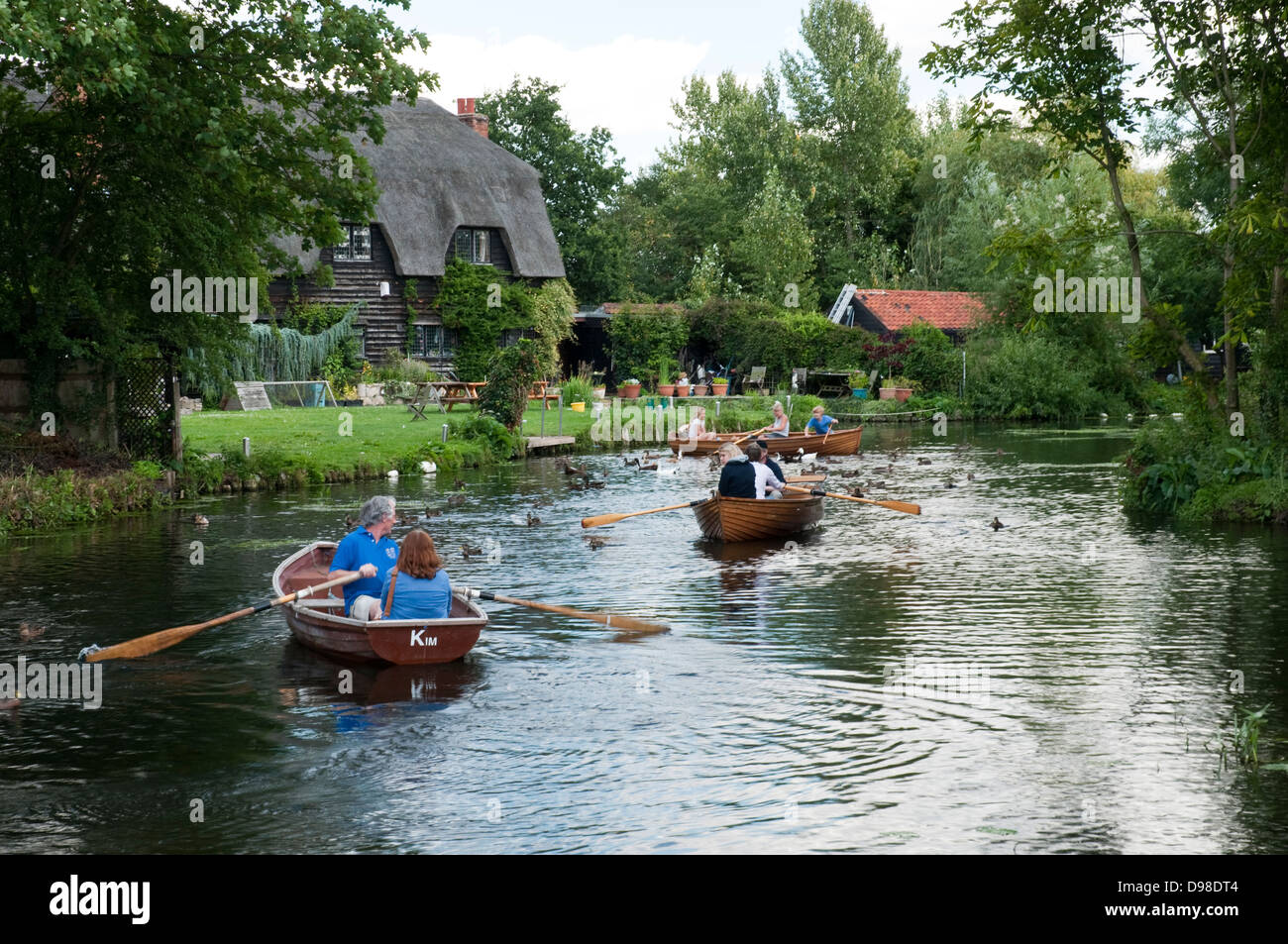 Adults and children seen boating on the river Stour beside a cottage at ...