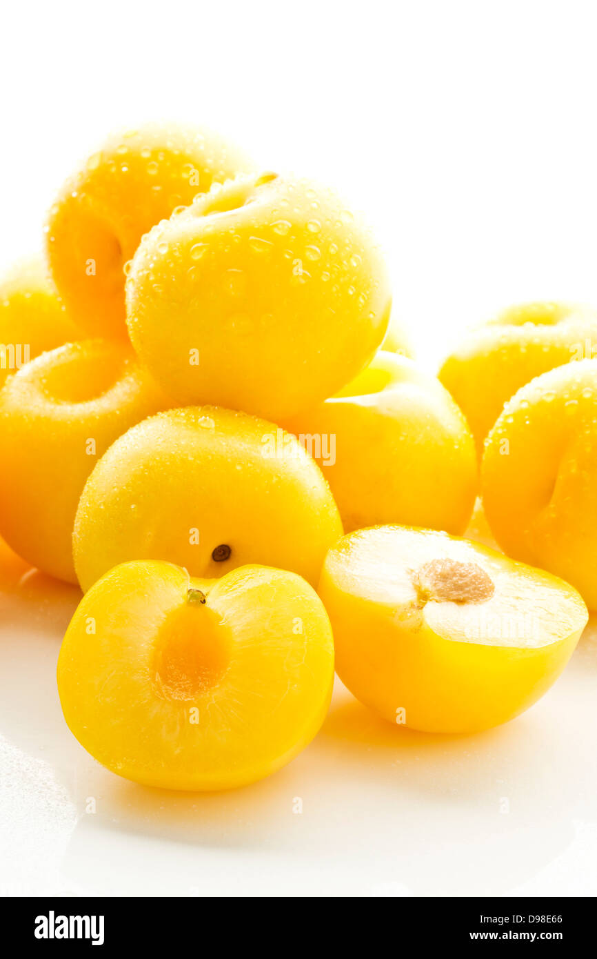 Yellow plums on white background, close up Stock Photo - Alamy