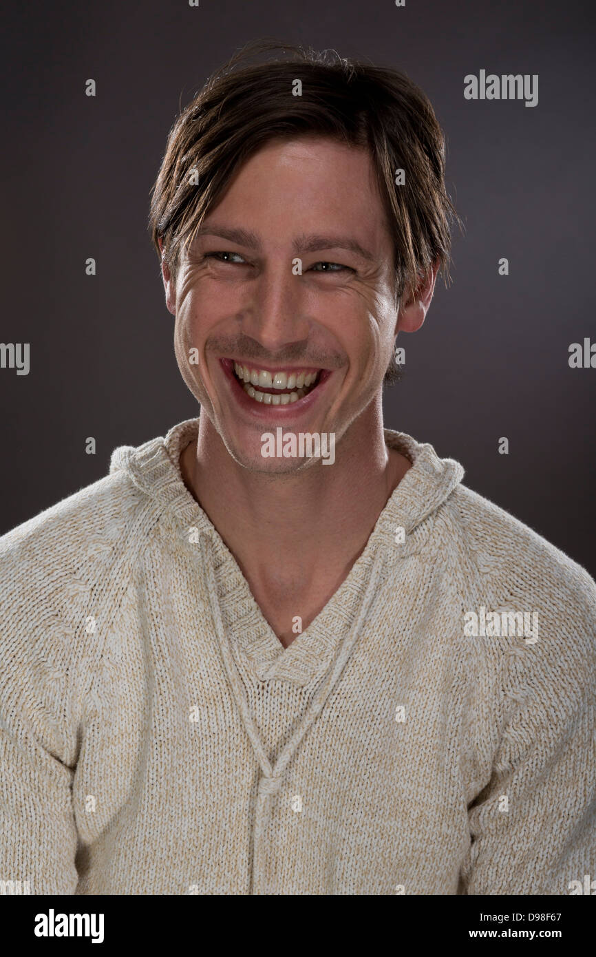 Portrait of young man against grey background, smiling Stock Photo - Alamy