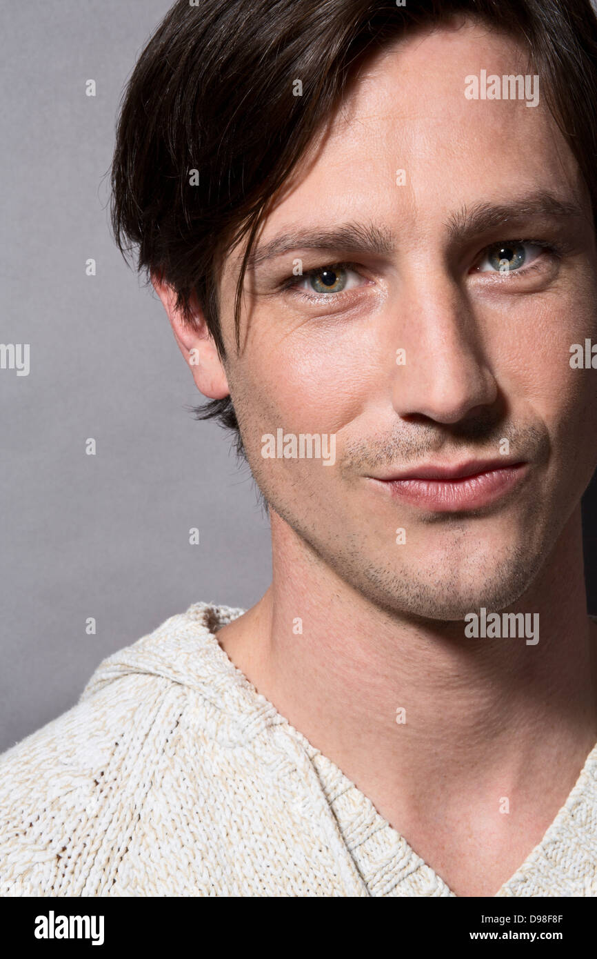Portrait of young man against grey background, smiling Stock Photo - Alamy