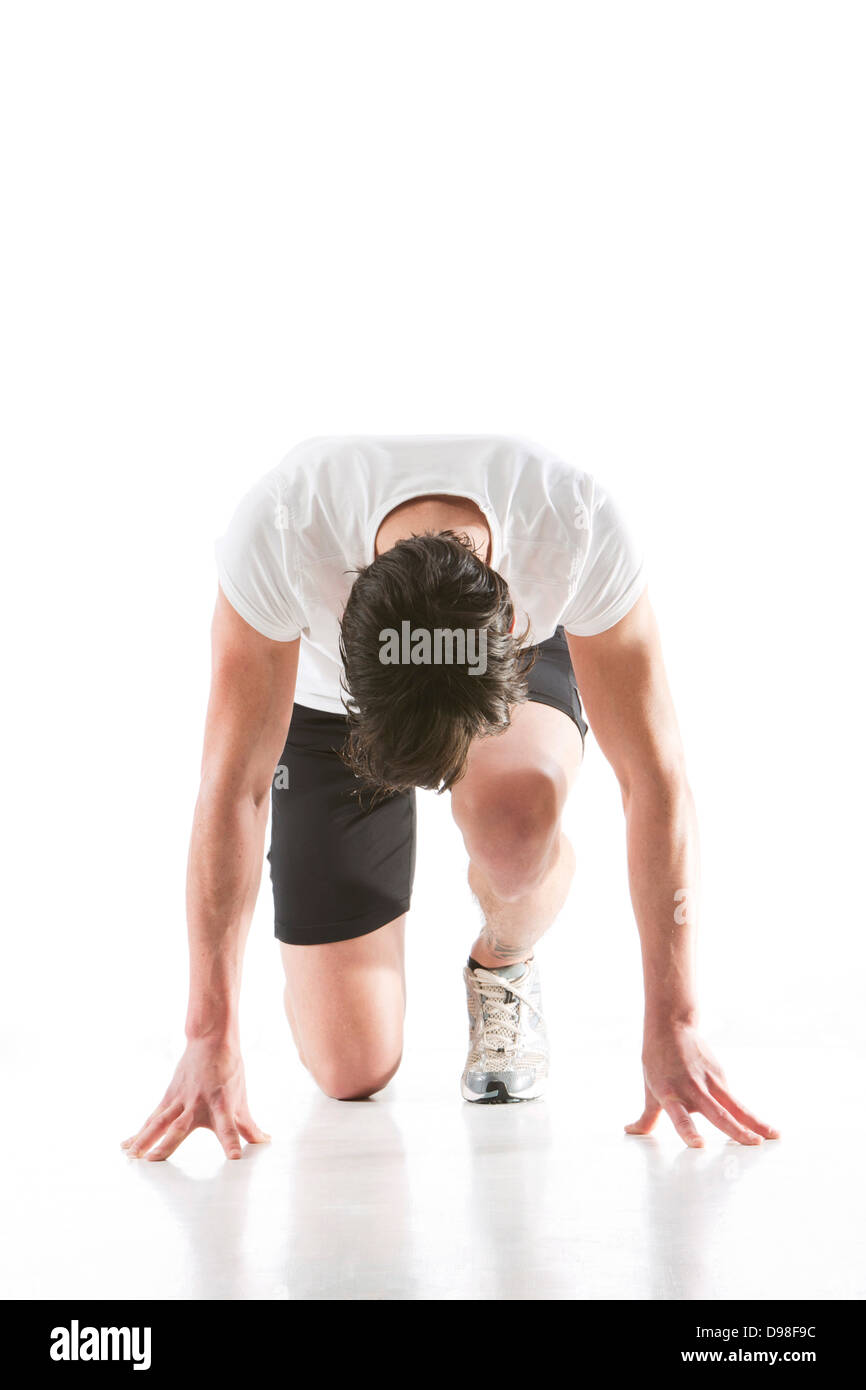 Young man in running position Stock Photo - Alamy
