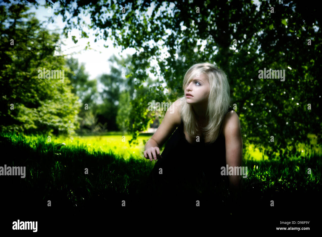 Blonde girl with long hair in sleeveless dress and apprehensive ...