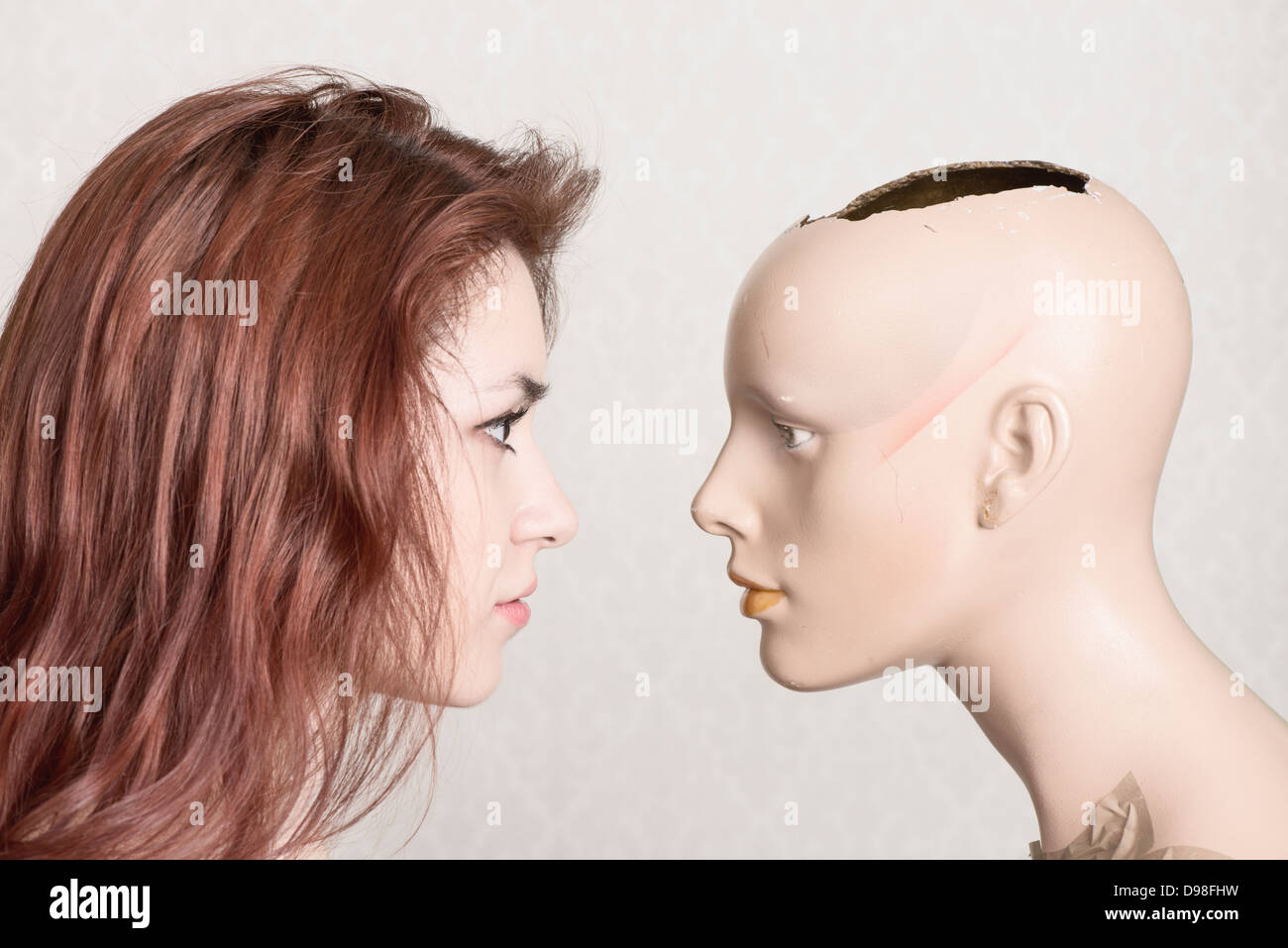 Young red haired woman in her 20s looking at broken mannequin Stock ...