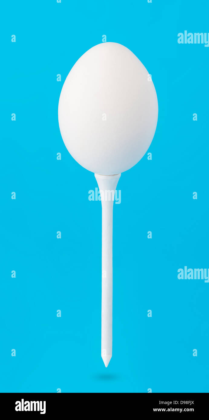 White egg balancing on golf peg Stock Photo - Alamy