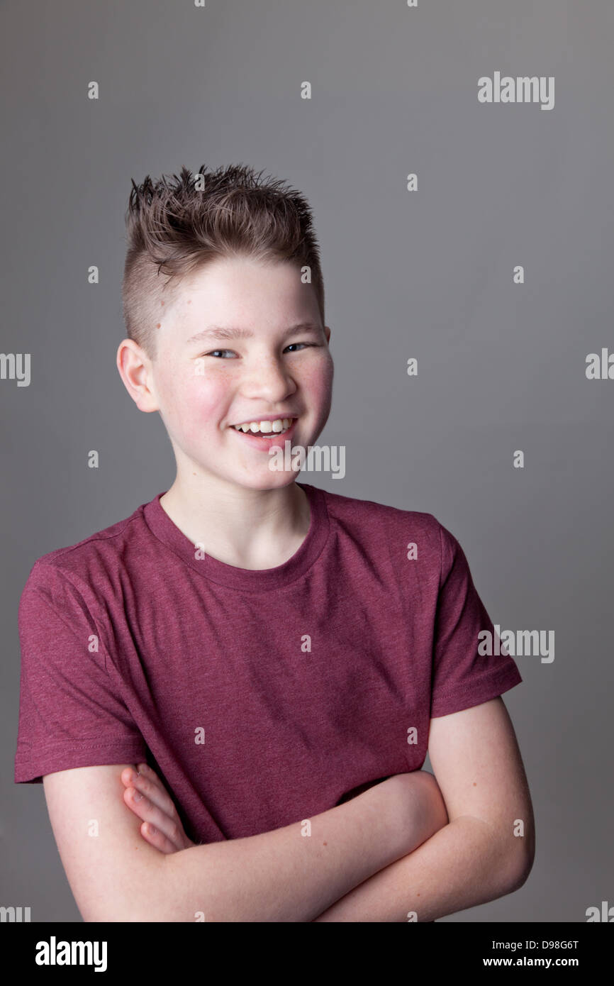 Eurasian (German, British, Japanese) boy laughing with folded arms ...