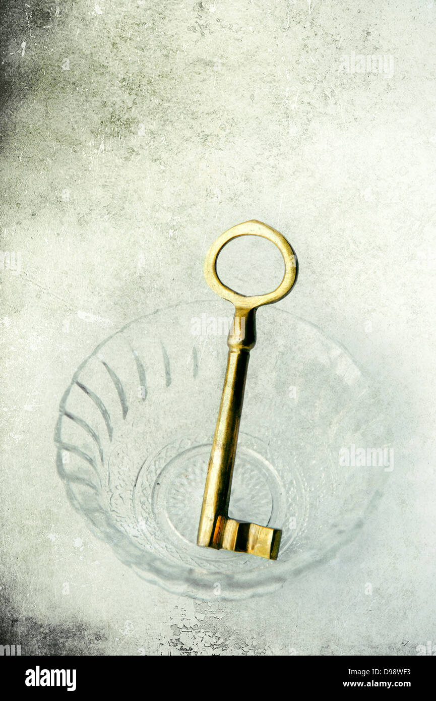 Old key sitting in glass dish Stock Photo - Alamy