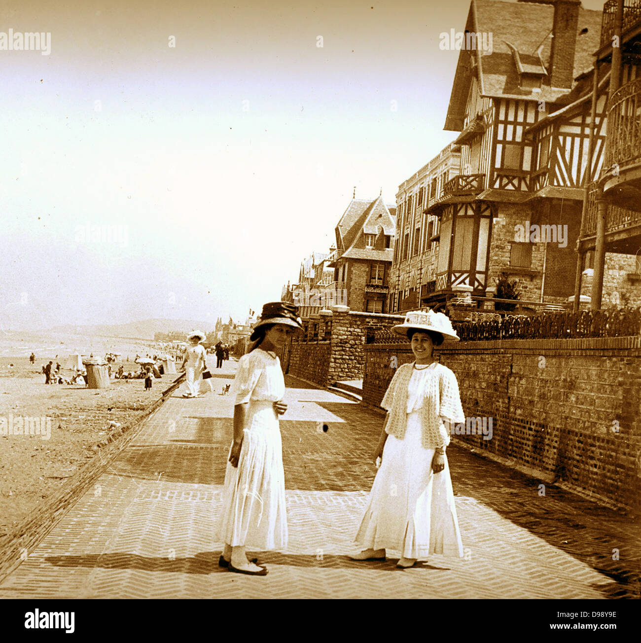 Two young women walk along promenade by beach in france hi-res stock ...