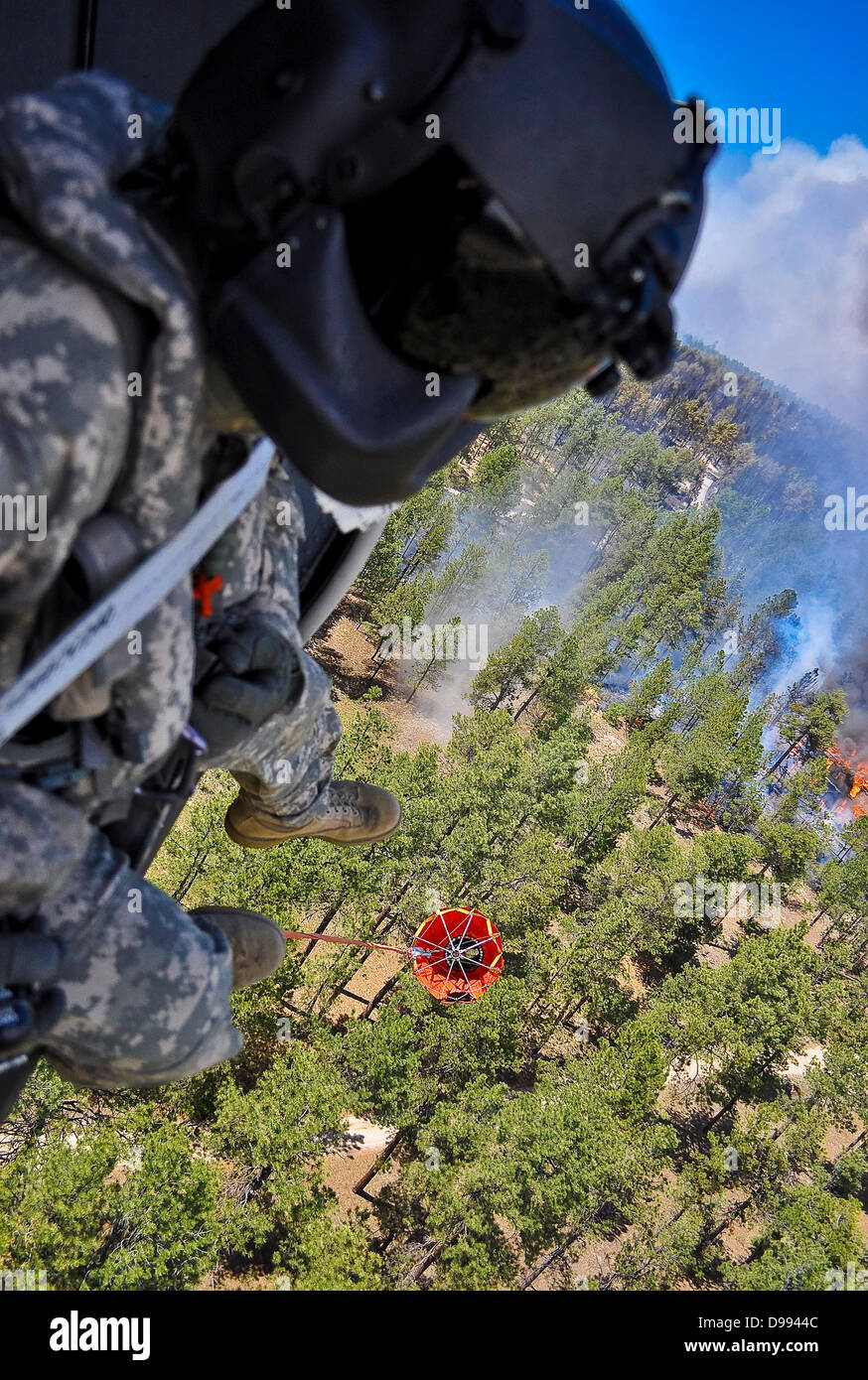 A US Army UH-60 Black Hawk helicopter carries a 500 gallon firefighting ...