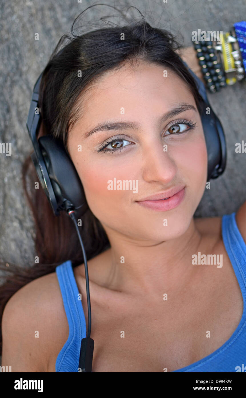 Attractive young mixed race woman listening to music in Central Park ...
