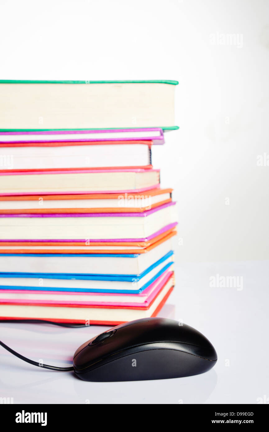 Stack of books with a computer mouse attached to it Stock Photo - Alamy