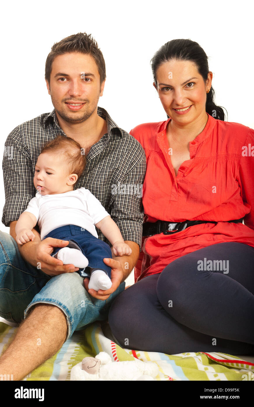 Beautiful family of three members sitting together on blanket against ...