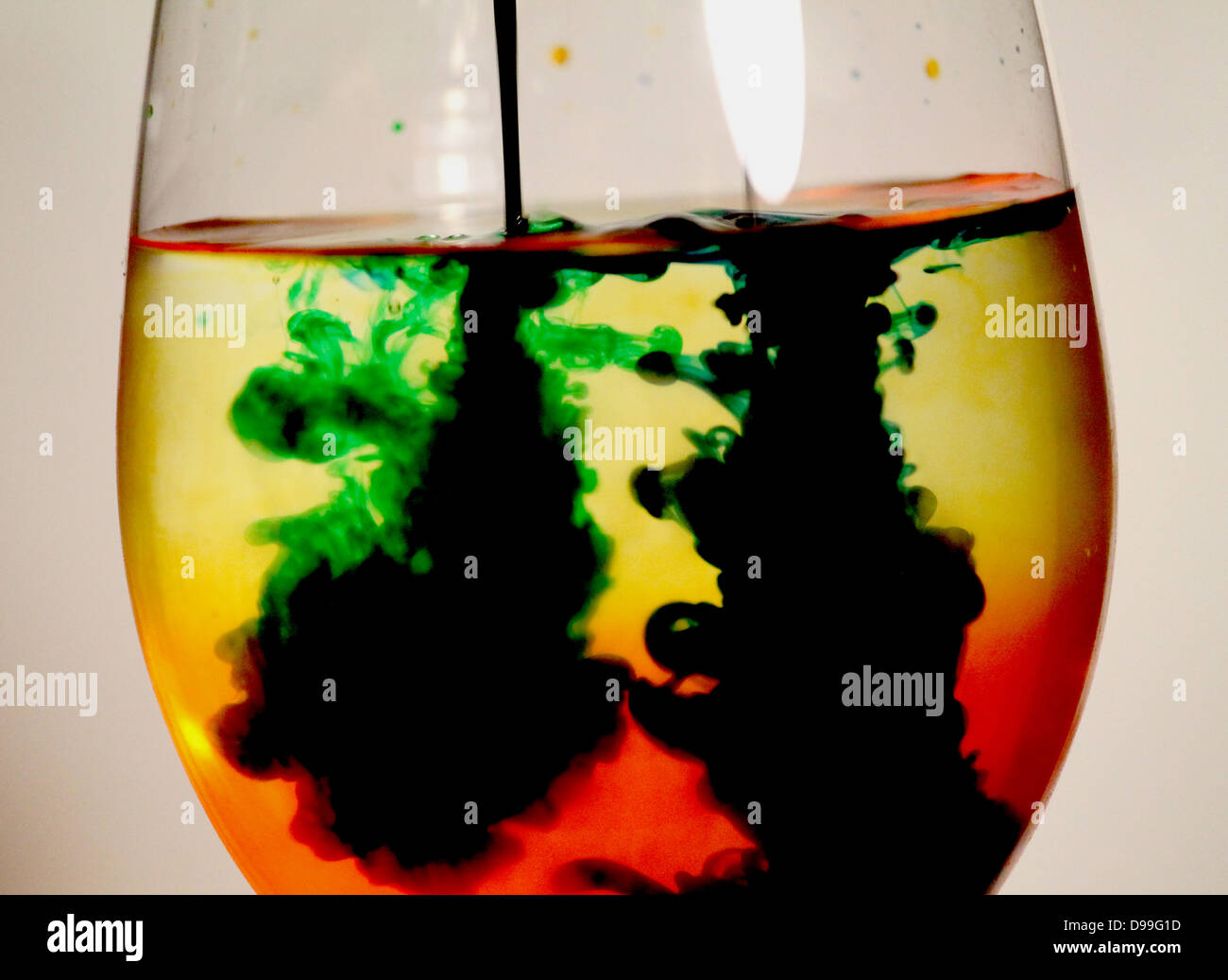 Ink being poured into a glass of water Stock Photo - Alamy