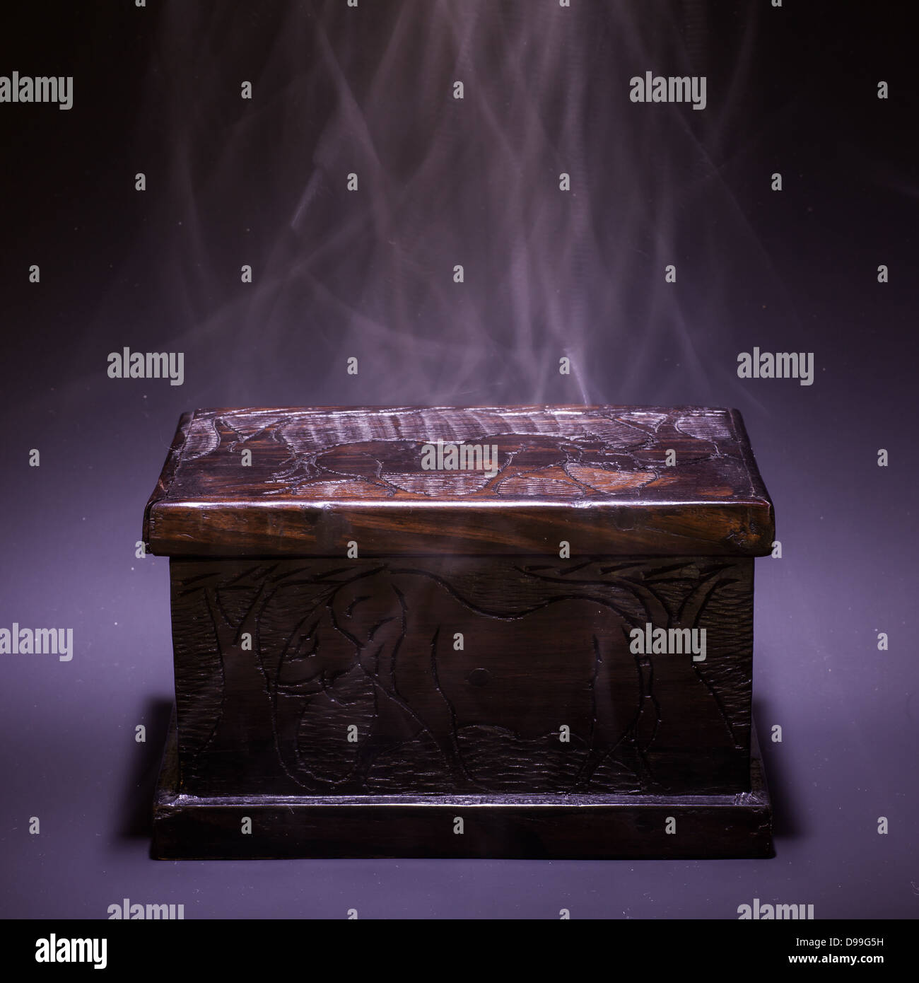 Ancient African box made of wood with light from the top and smoke ...