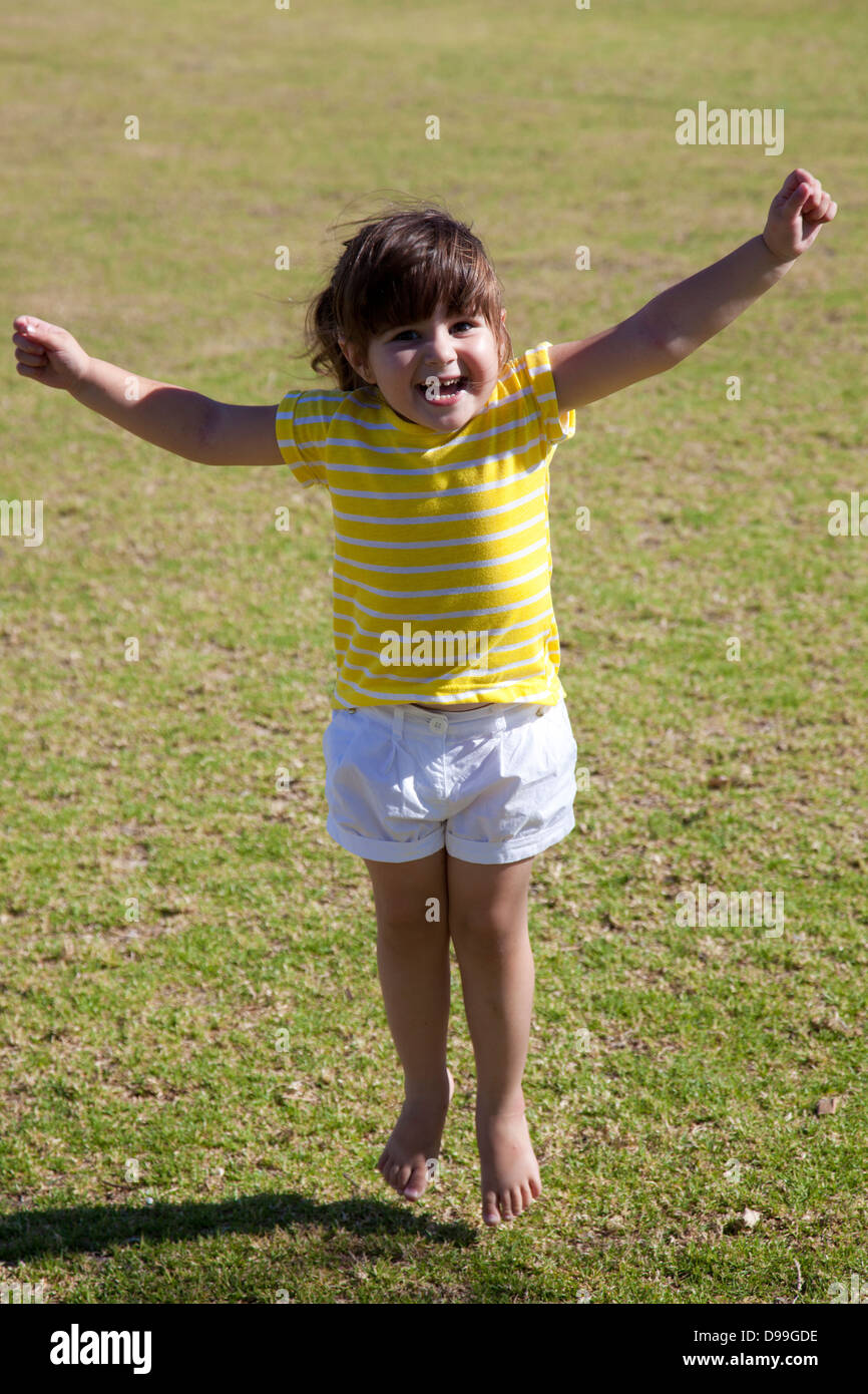 Girl Jumping on Grass Stock Photo - Alamy
