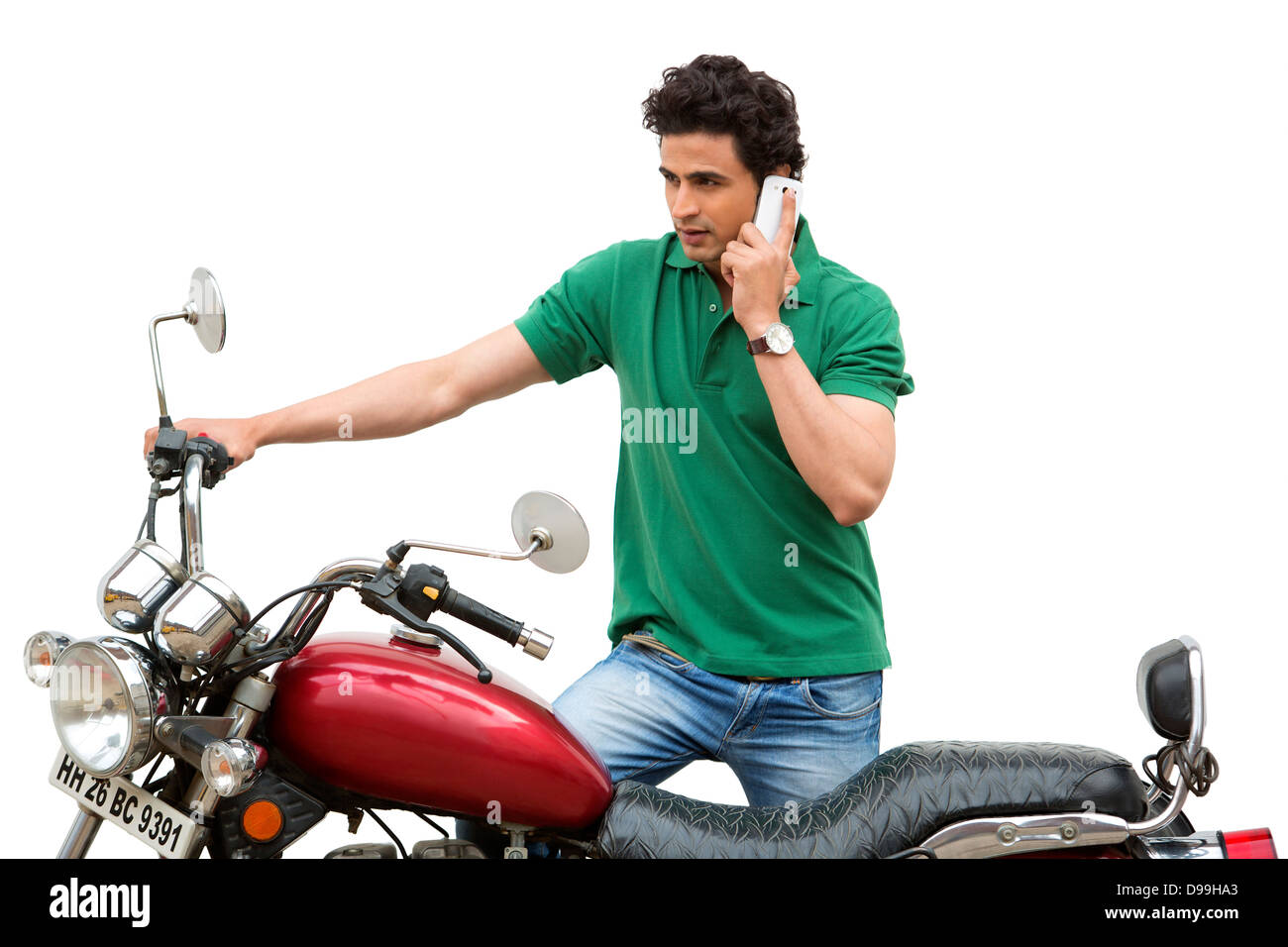 Man standing beside a motorcycle and talking on a mobile phone Stock ...