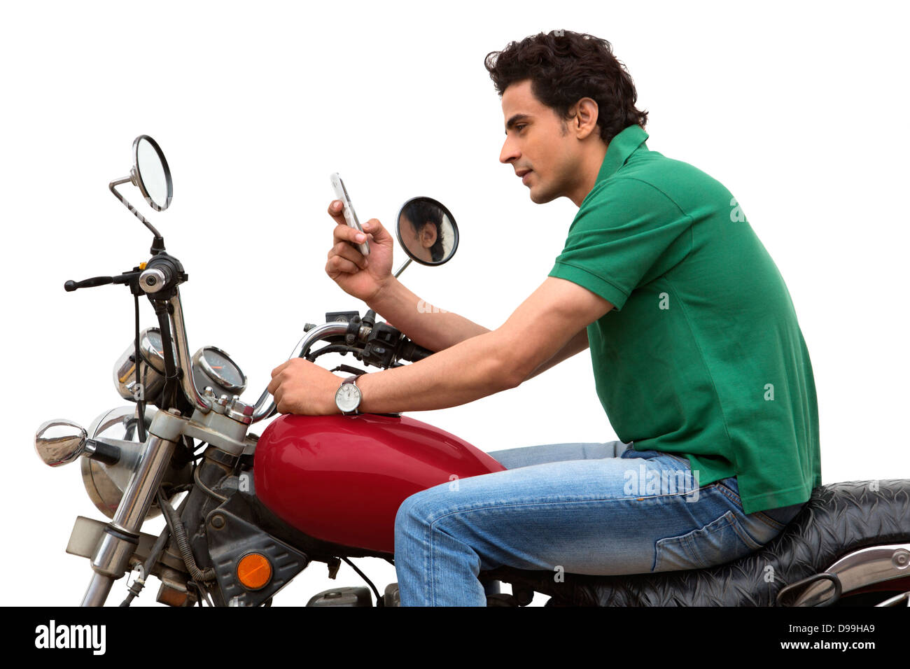 Man text messaging on a mobile phone while sitting on a motorcycle ...