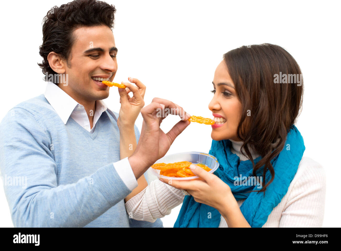 Smiling couple eating jalebis Stock Photo - Alamy